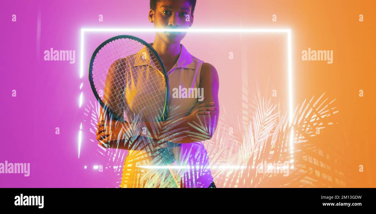 African american female tennis player holding racket by illuminated ...