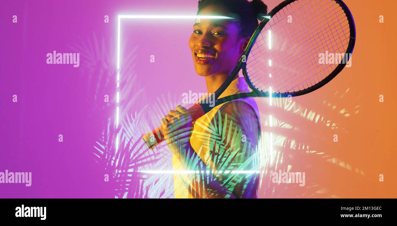 Smiling african american female tennis player with racket standing by ...