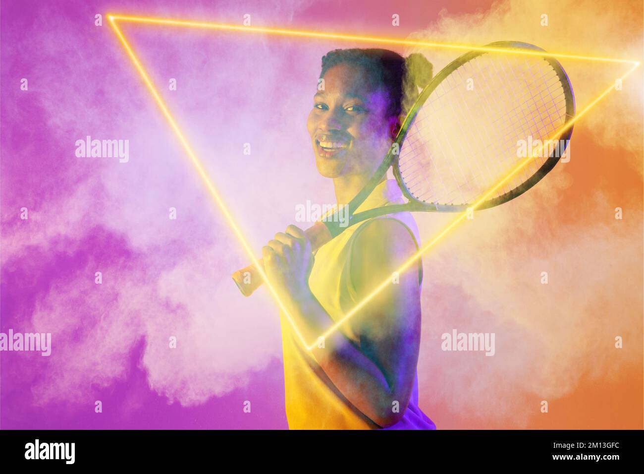 Smiling african american female tennis player with racket amidst smoke ...