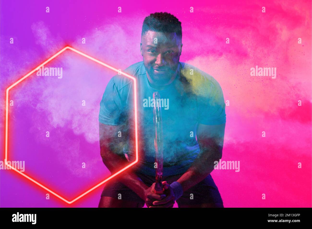 African american male tennis player with racket bending by illuminated ...