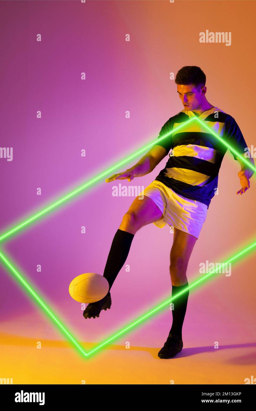 Caucasian male rugby player kicking ball by illuminated rectangle over ...