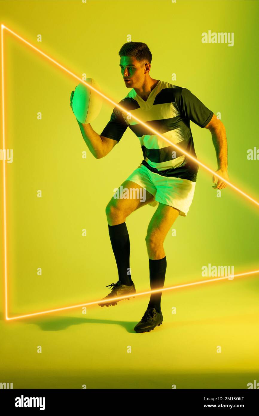Caucasian male rugby player with ball by illuminated triangle against ...