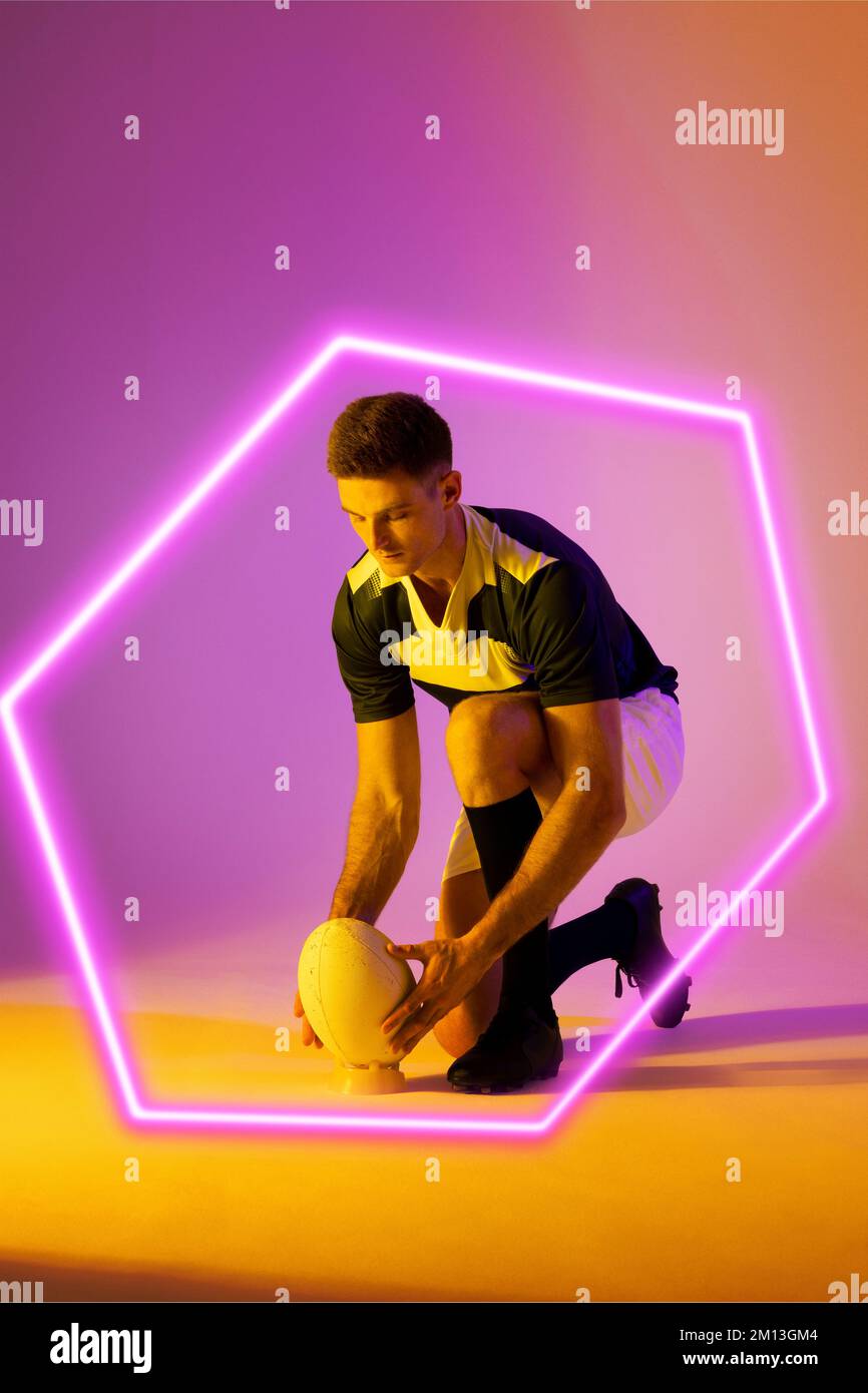 Caucasian male rugby player placing ball on stand by illuminated ...