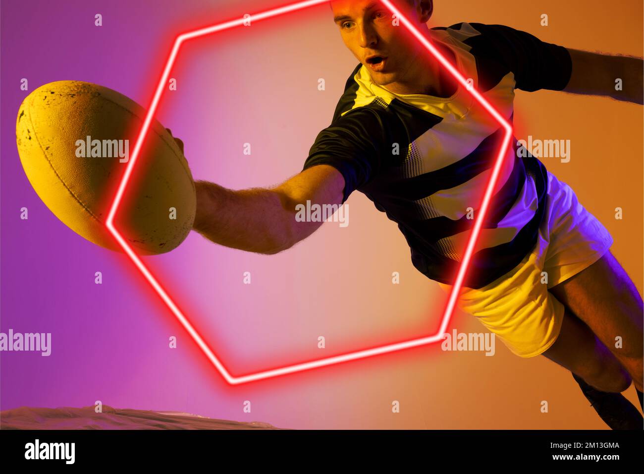 Caucasian male rugby player with ball jumping by illuminated hexagon on ...