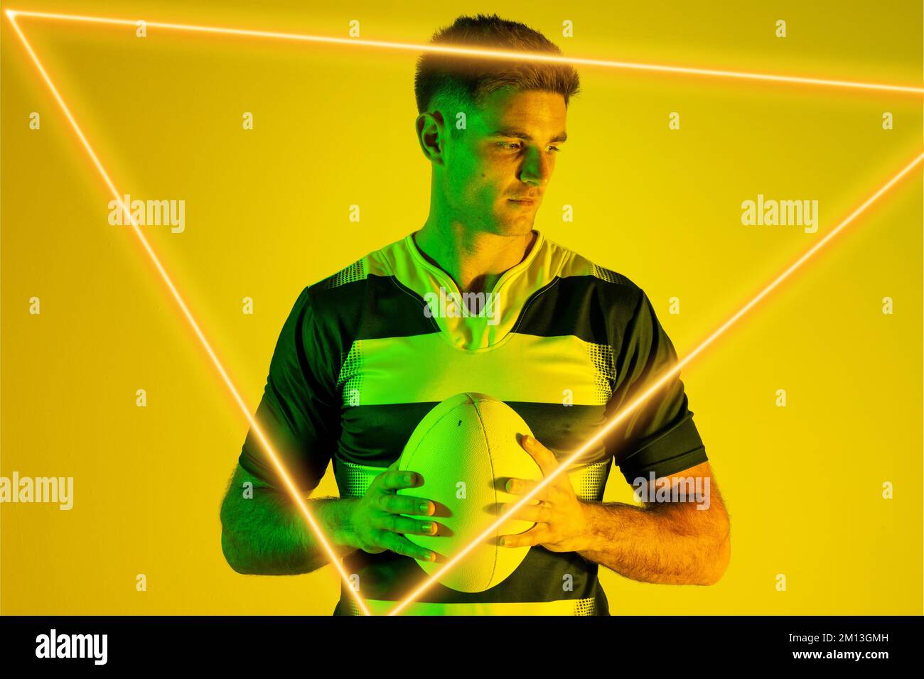 Caucasian male rugby player with ball looking away by illuminated ...