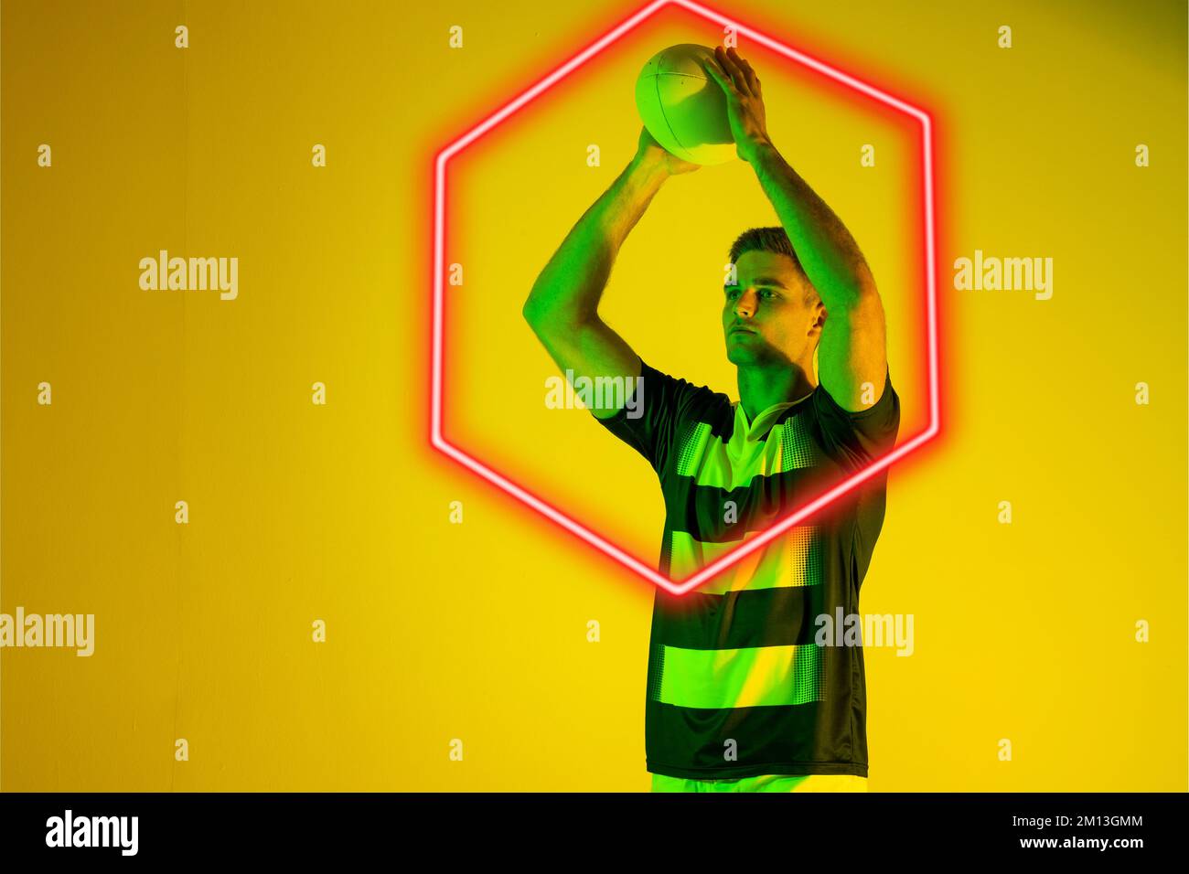 Caucasian male rugby player throwing ball by illuminated hexagon over ...