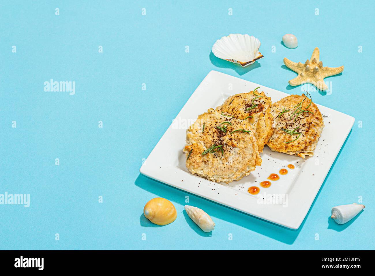 Hake fillet fried in batter. Sauce, fresh rosemary, nautical decor ...