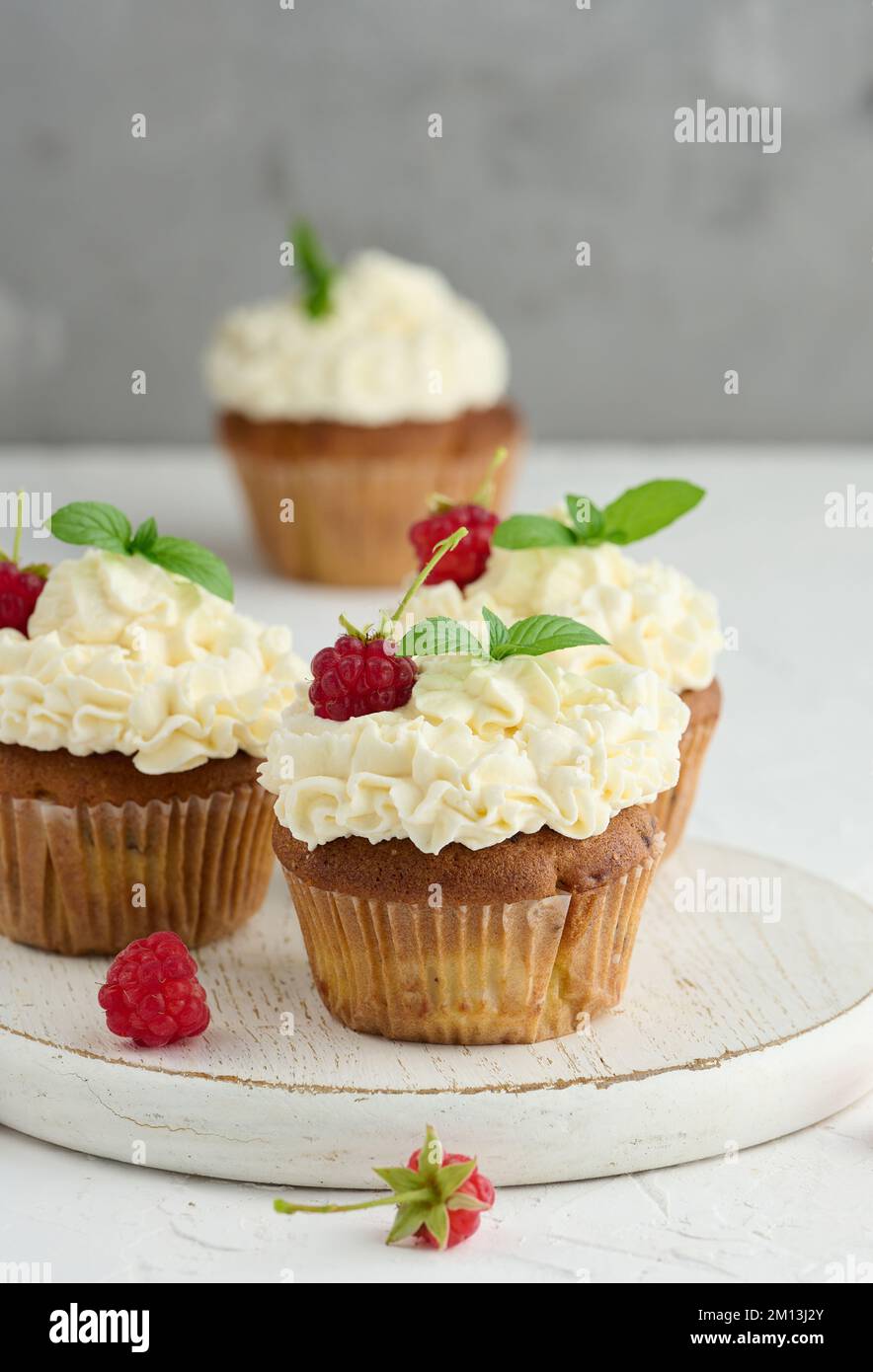 Baked cupcakes with white butter cream on the table, delicious dessert ...