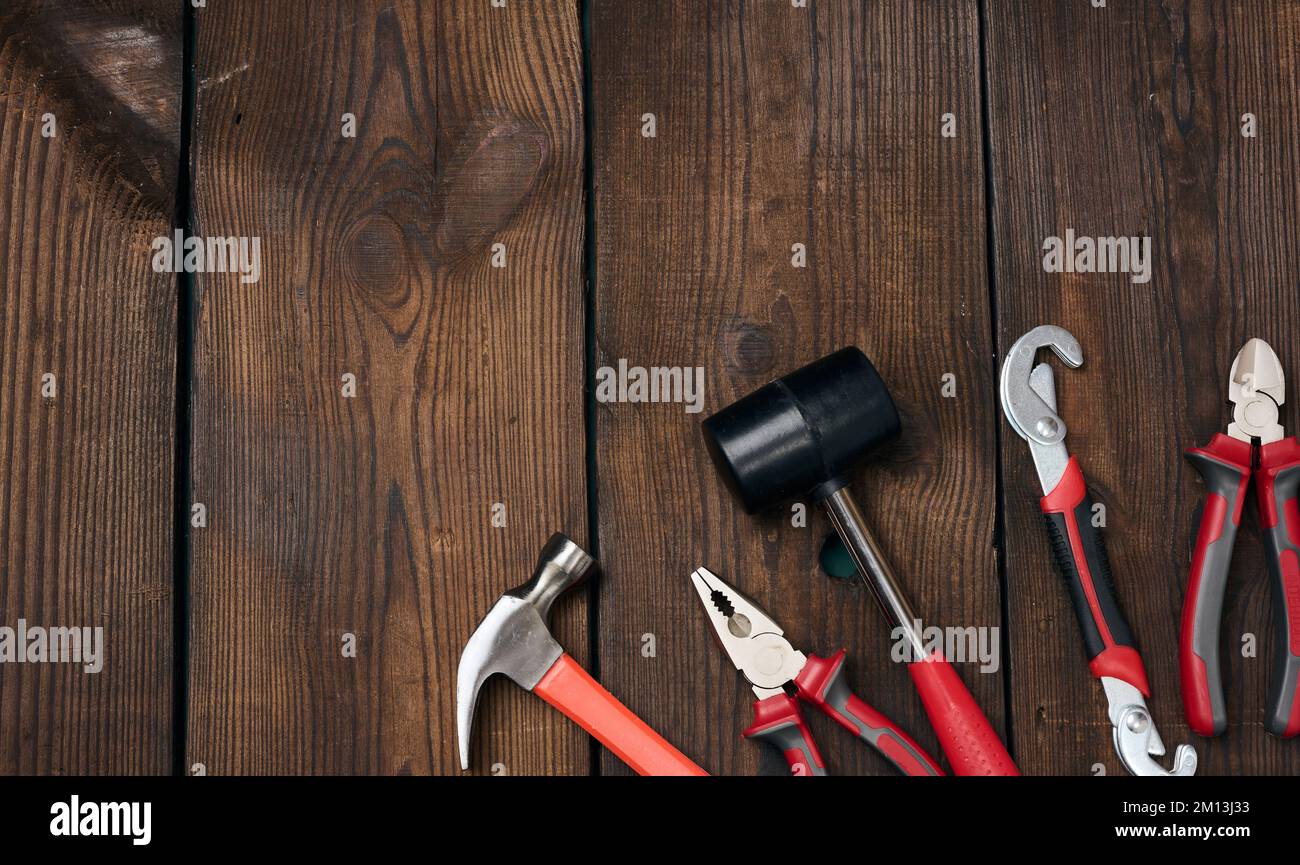 A set of construction tools on a brown wooden background, top view ...