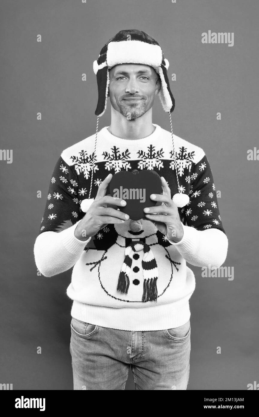 cheerful man in winter sweater and hat hold love heart on red ...