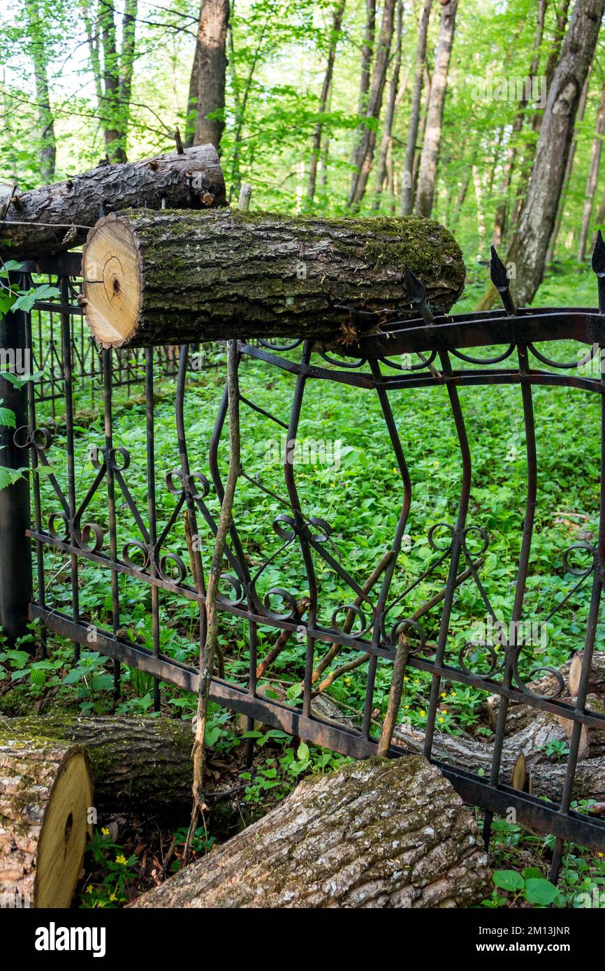 A bent metal fence on which a tree fell, a strong blow bent the fence ...