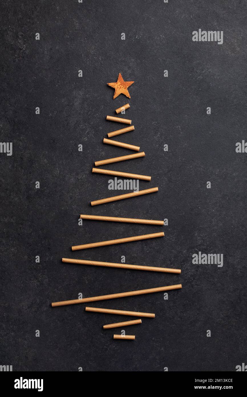 Creative Christmas tree made from paper straws for cocktails on dark ...