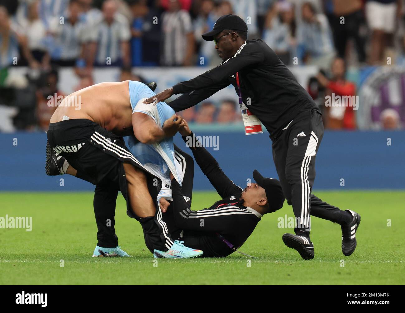 Lusail, Qatar. 9th Dec, 2022. A pitch invader (1st L) is tackled by ...