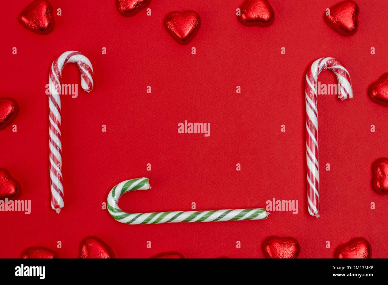 red festive Christmas background with candy in the shape of hearts ...