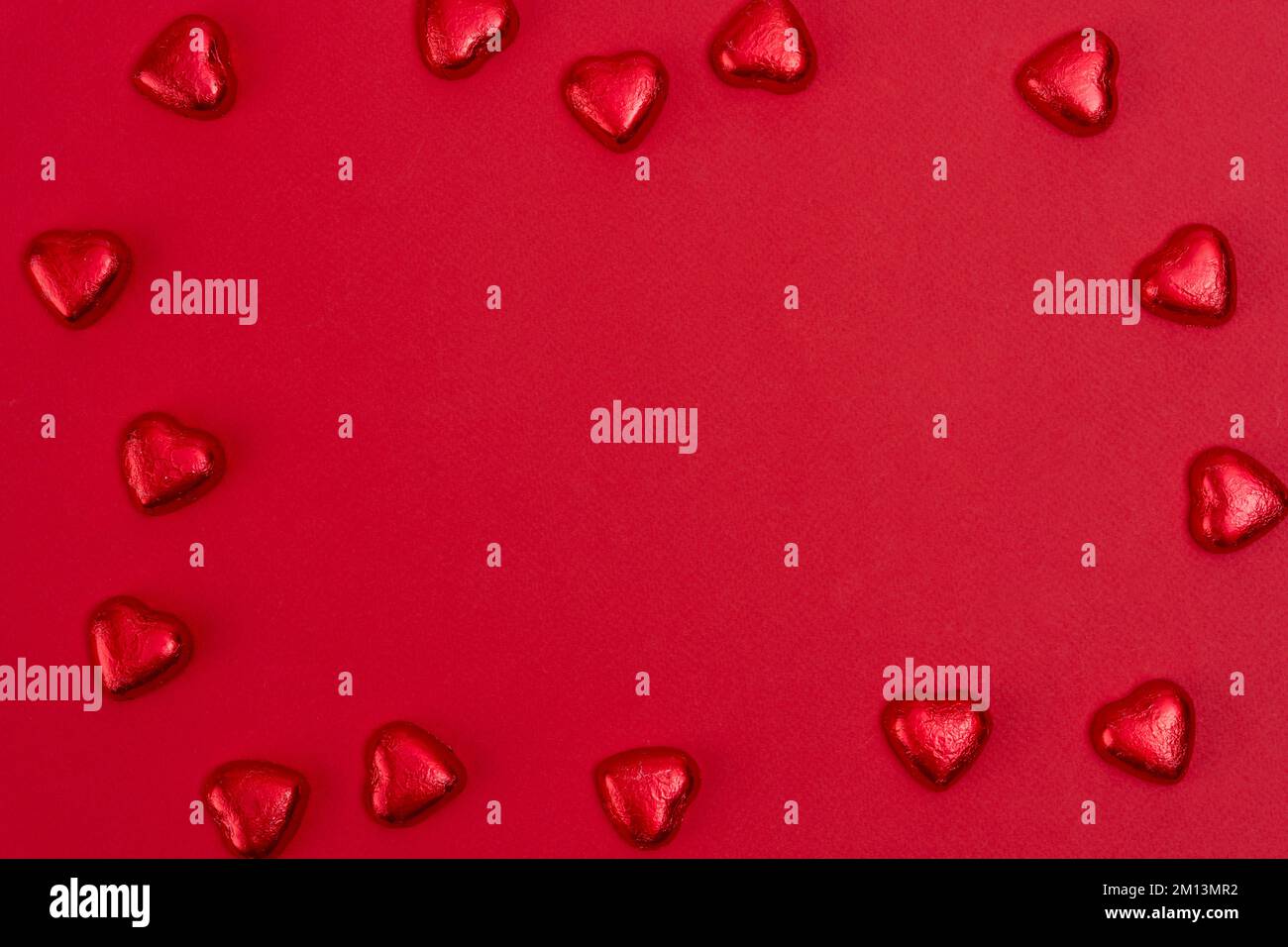 red festive Christmas background with candy in the shape of hearts ...