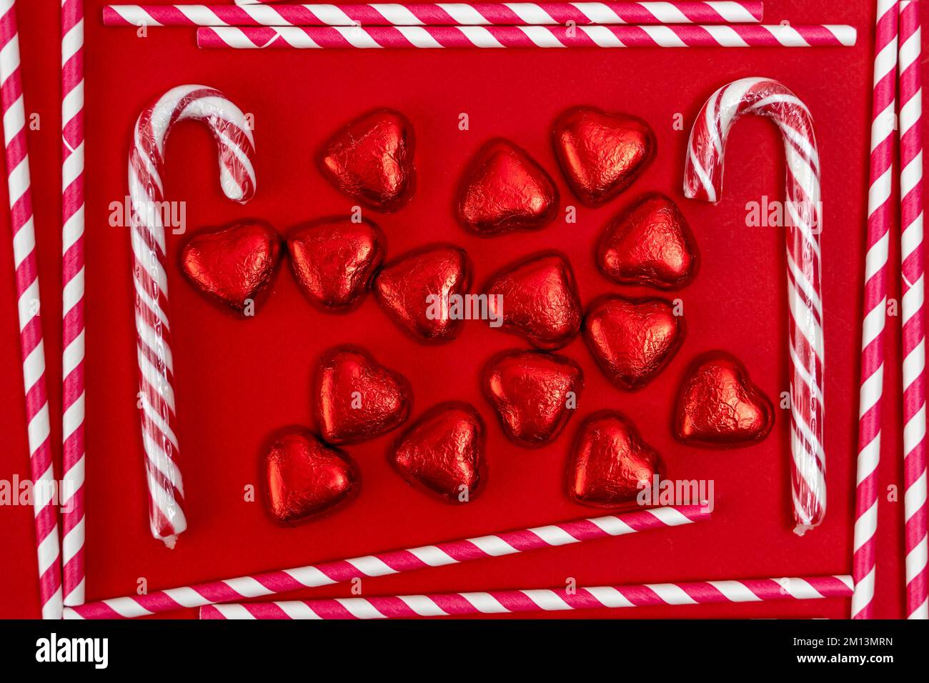 red festive Christmas background with candy in the shape of hearts ...