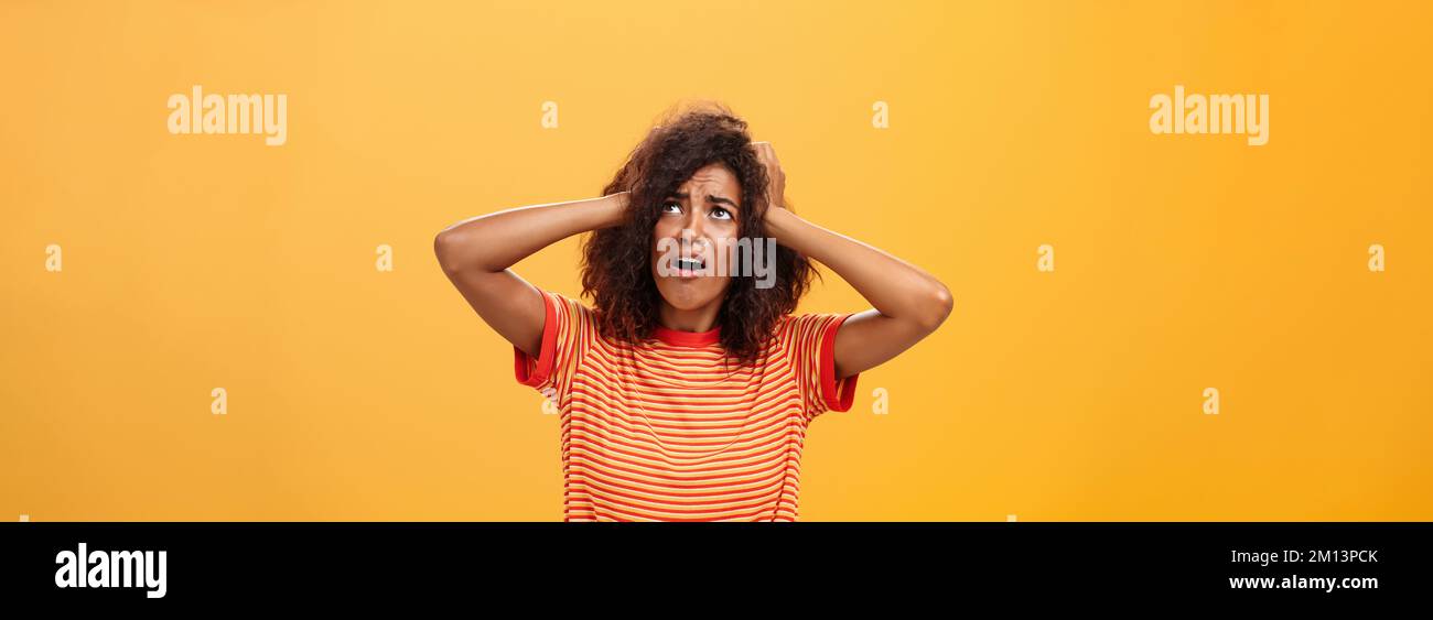 Displeased moody african girlfriend holding hands on head and frowning ...