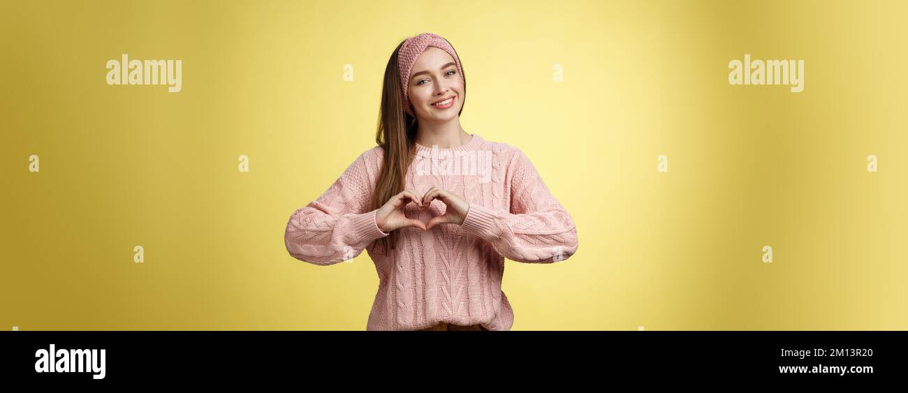 Girl brings peace and love, smiling tender, lovely showing heart ...