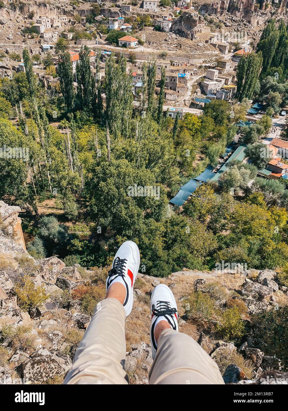 Tourist man outdoor on edge of cliff. Closeup legs over the abyss Stock ...