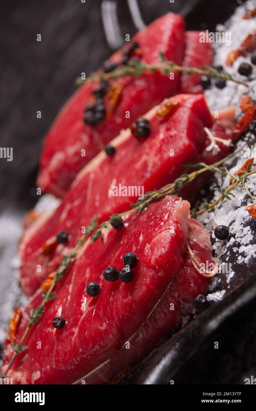 Raw steak seasoned on a cast iron pan Stock Photo - Alamy