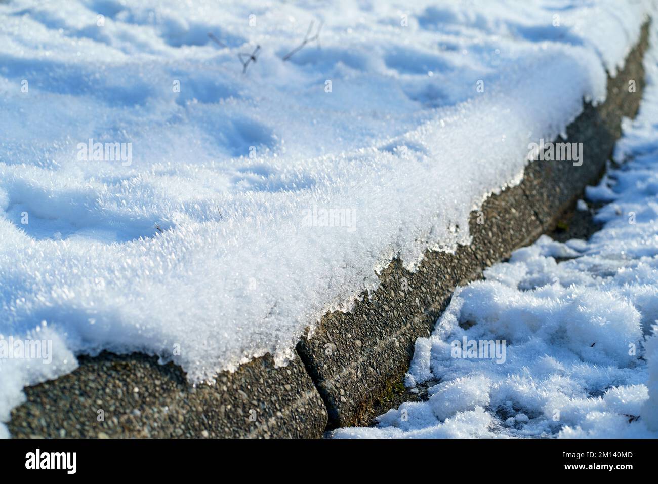 Frosty snow on cement curb in sunlight Stock Photo - Alamy