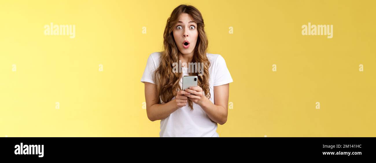Shocked impressed speechless girl say wow curly hairstyle stare camera ...