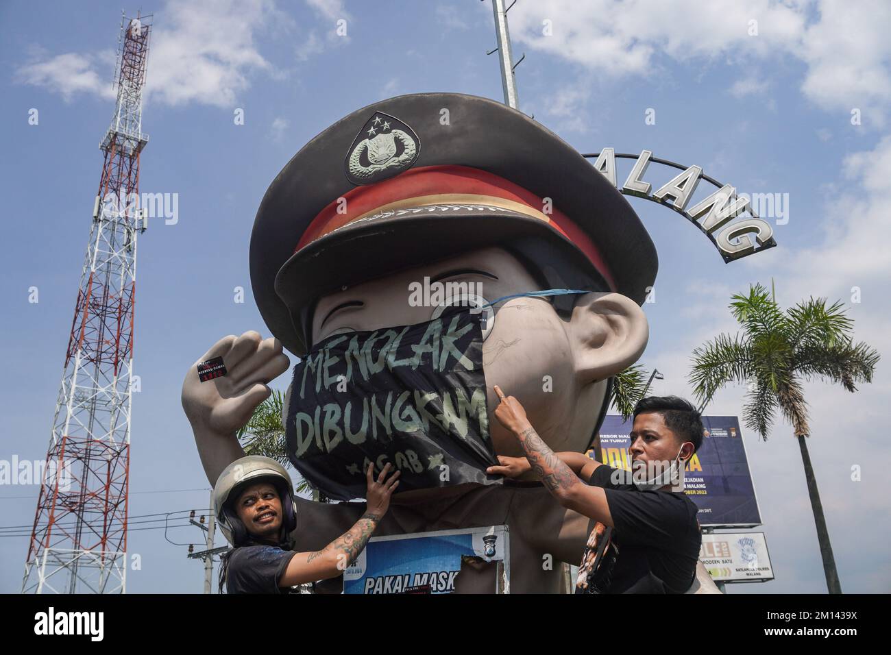 Demonstrators cover a police statue with a banner with the words ...
