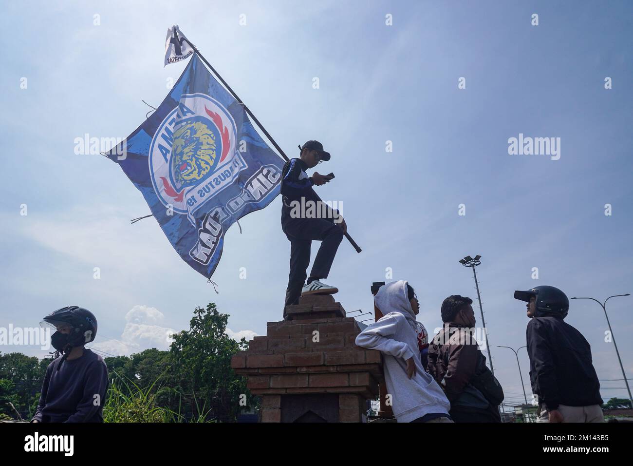 A demonstrator holds a flag with the Crazy Lion logo of the soccer team ...