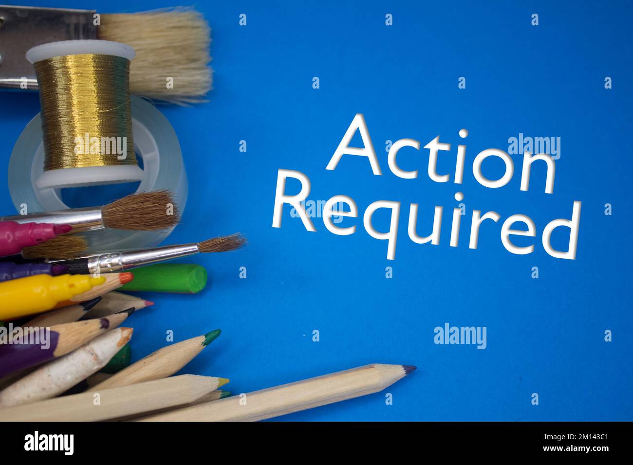 Overhead shot of school supplies with Action Required text. Brushes ...