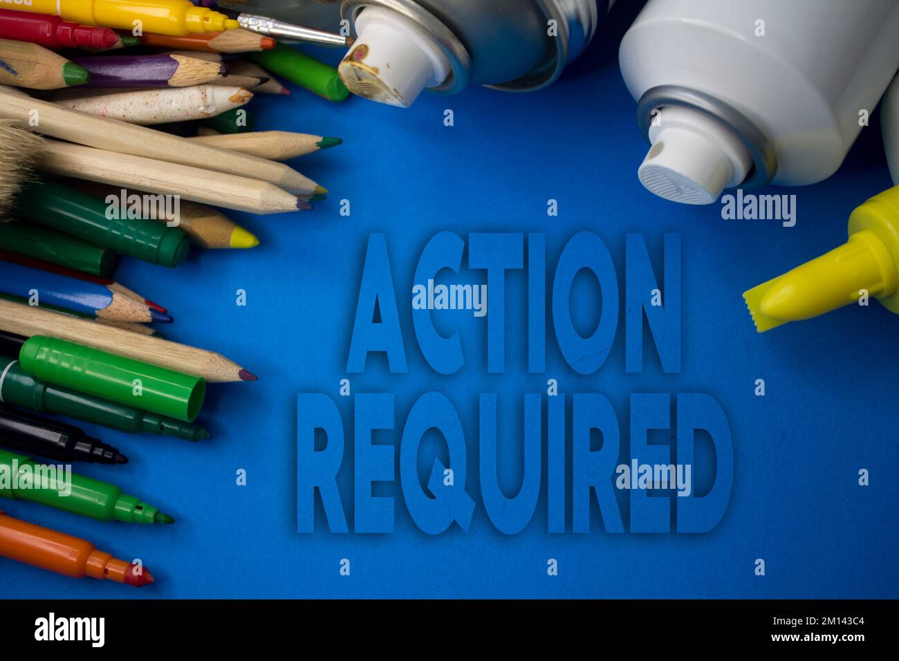 Overhead shot of school supplies with Action Required text. Brushes ...