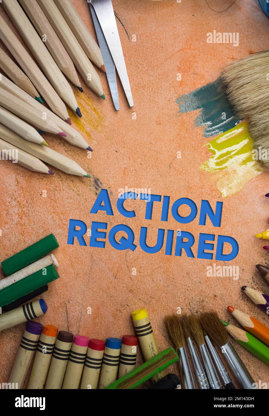 Overhead shot of school supplies with Action Required text. Brushes, pencils, artistic tools ...