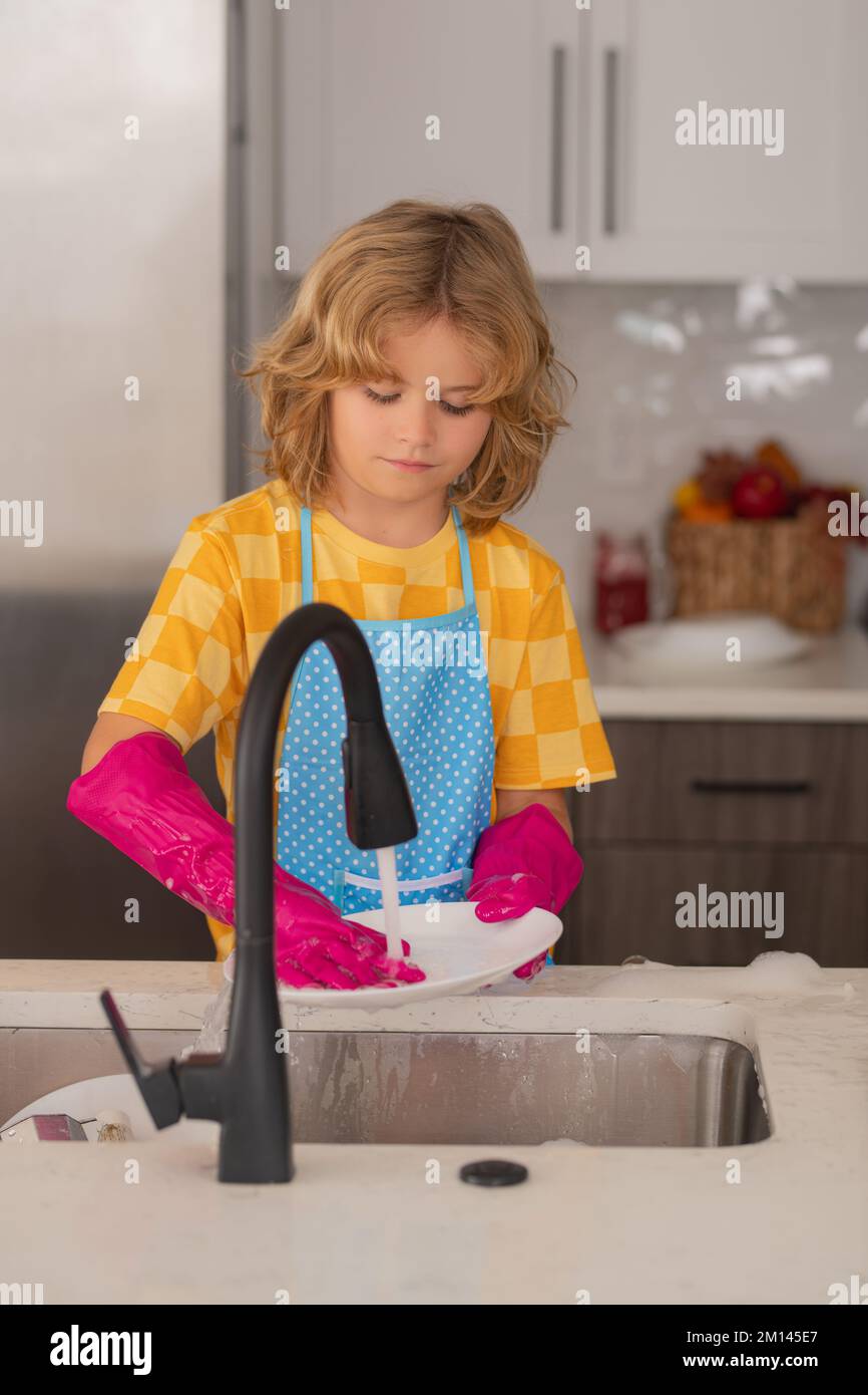 Cleaning at home. Kid washing dishes in the kitchen interior. Child ...