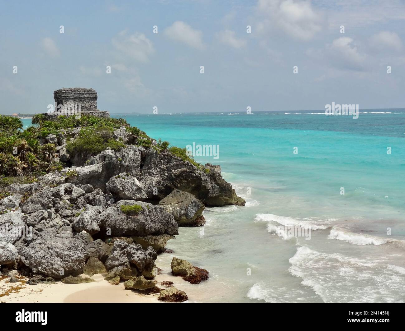 A landscape scene of Tulum Mayan Ruins Beach with mossy rocks by ...