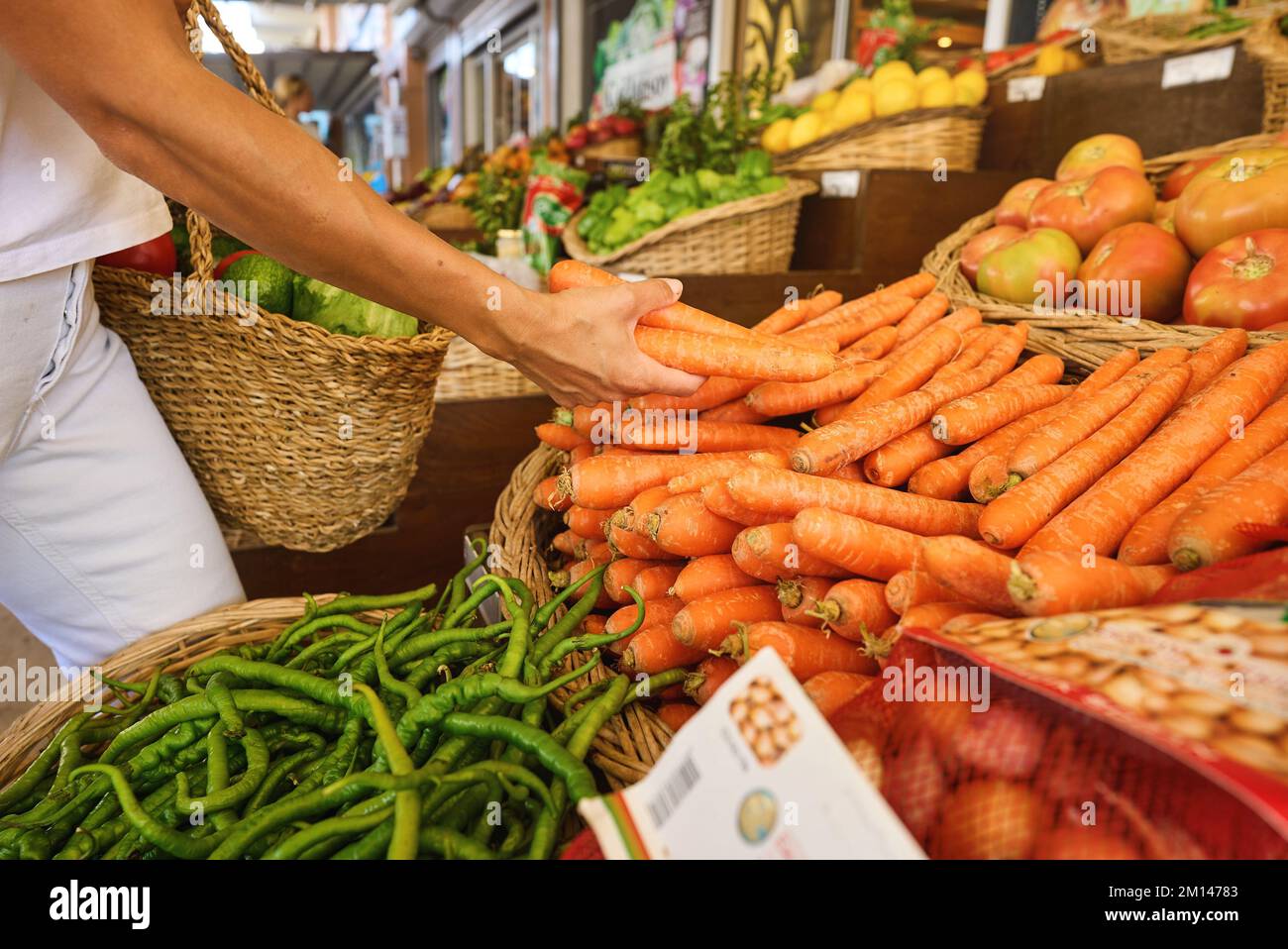 Buying fresh organic produce at the farmers' market. A woman chooses ...