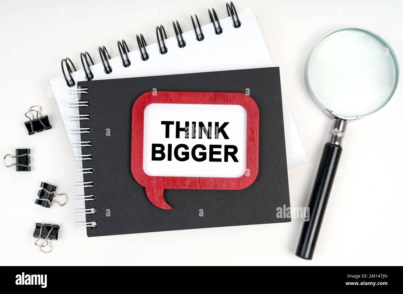 Business concept. There is a magnifying glass, a notebook and a sign on ...