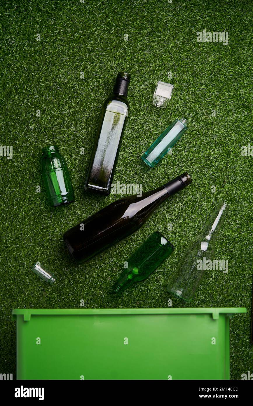 Separate collection of glass garbage. Recyclable glass waste on green ...