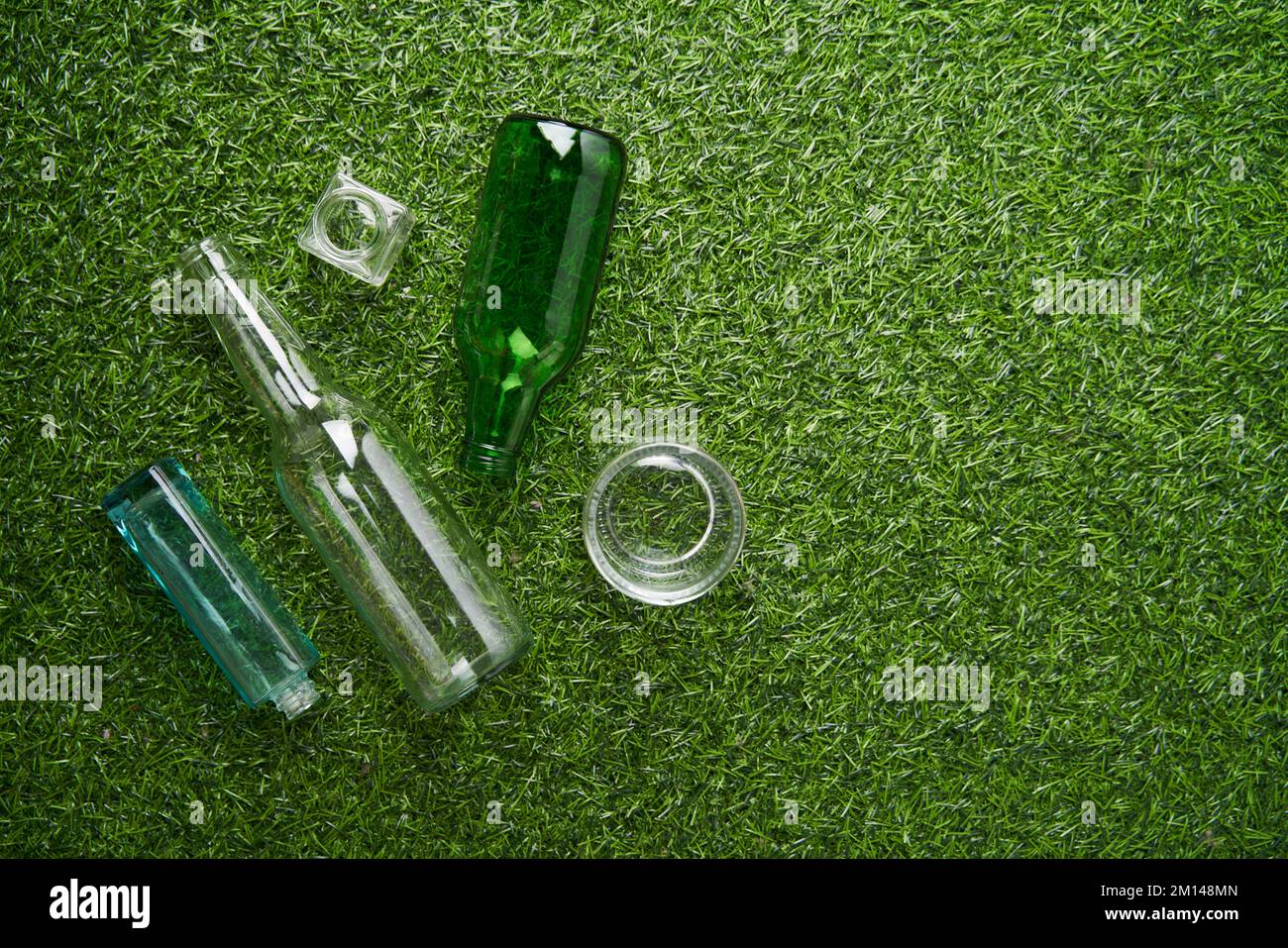 Separate collection of glass garbage. Recyclable glass waste on green ...