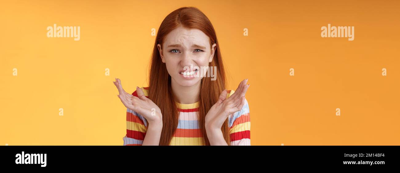 Awkward unhappy worried young redhead girl cringe feel sorry ...