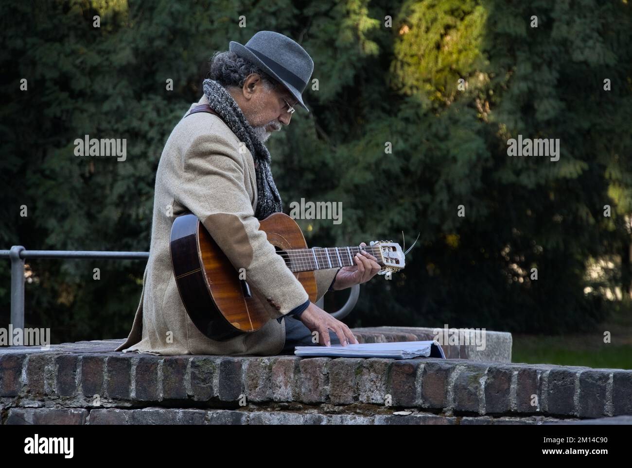 A man with guitar reading his notes Stock Photo - Alamy