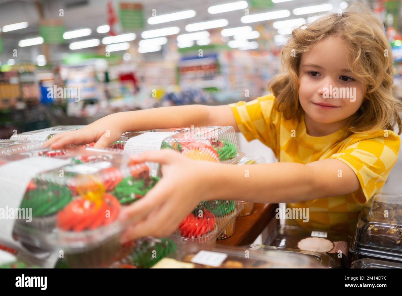 Kid choosing cakes, cupcake muffin. Shopping in supermarket or grocery ...