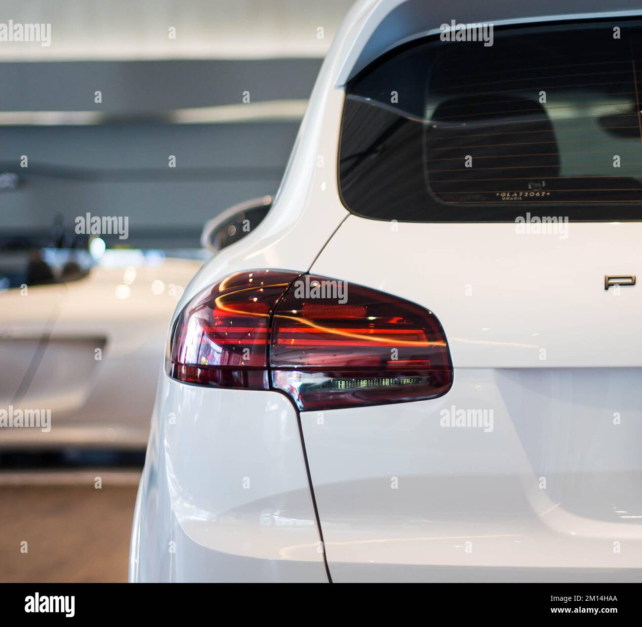 A red taillight of a white Porsche Cayenne GTS Old Generation in a ...