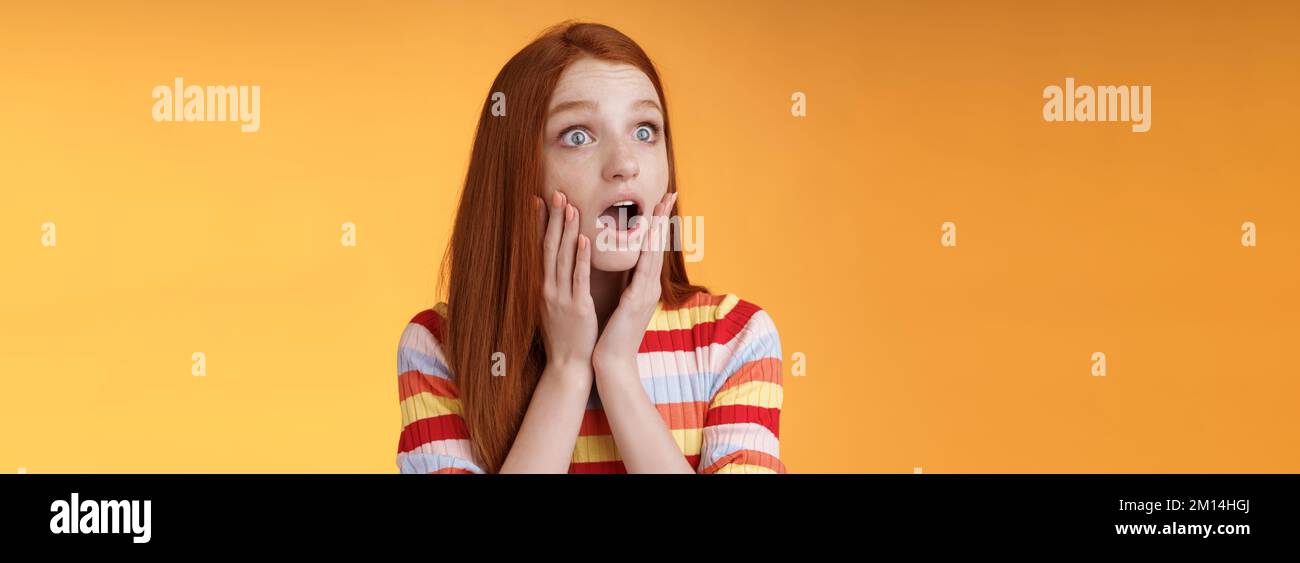 Shocked amazed young drama girl redhead blue eyes gasping empathy touch ...