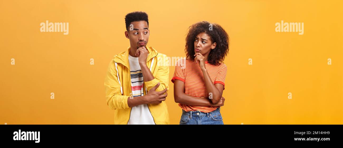 Silly confused girl standing gloomy and worried pursing lips and ...