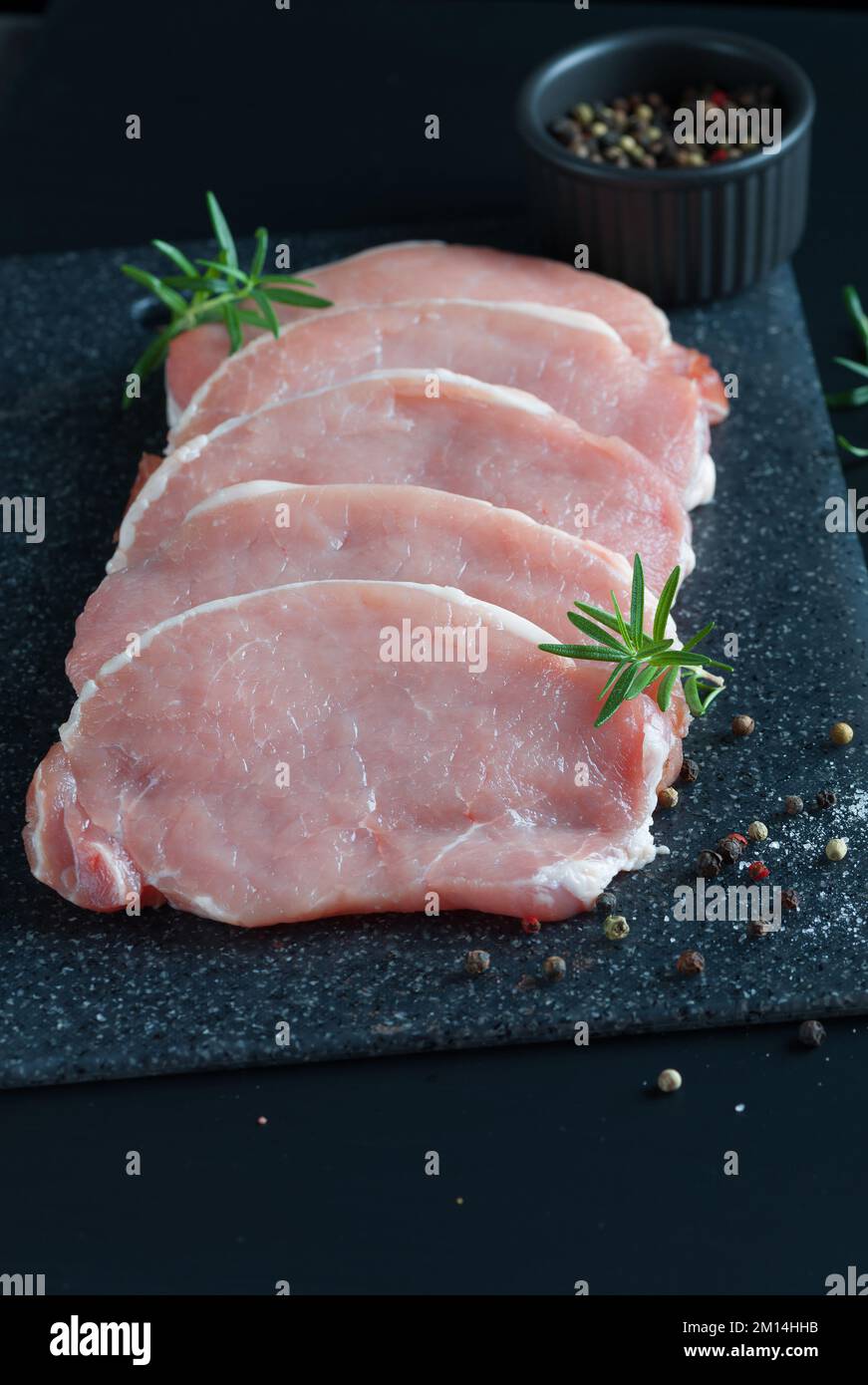 Raw sliced pork. Black background. Top view Stock Photo - Alamy