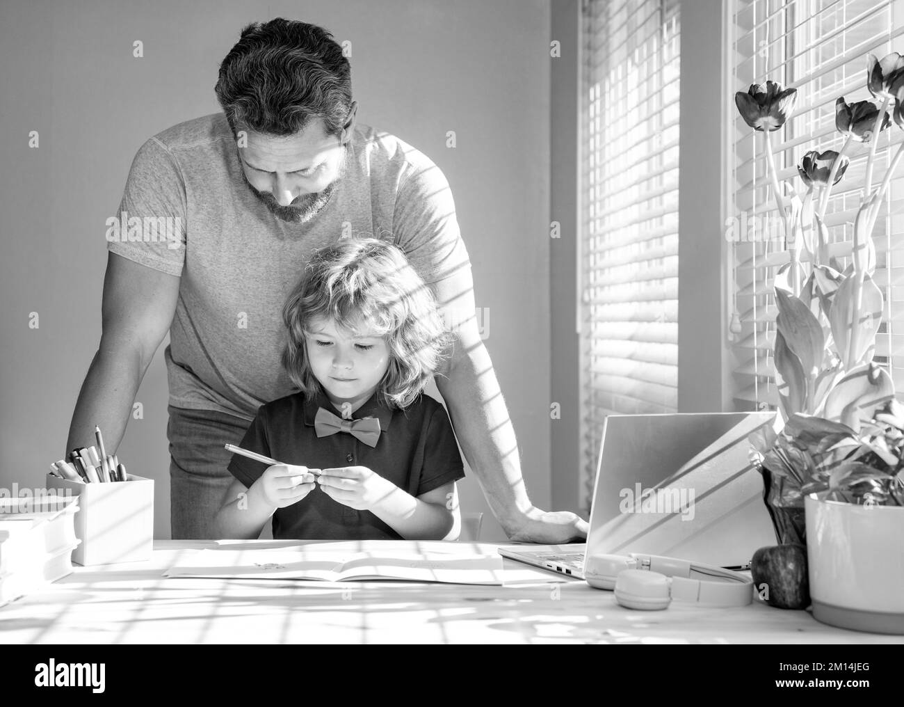 bearded daddy writing school homework with his child son in classroom ...