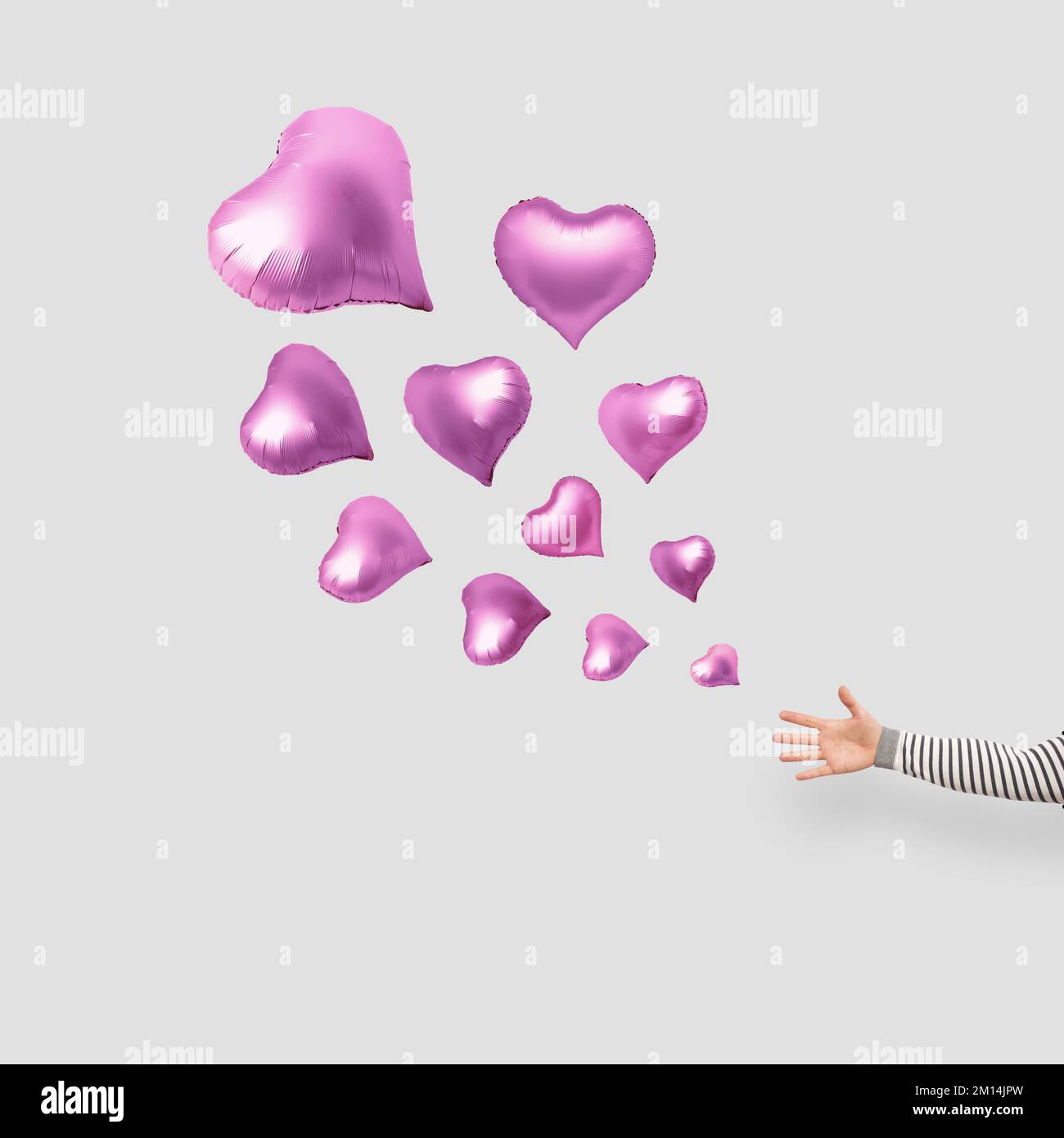 The pink heart shaped helium balloons floating on the white background ...