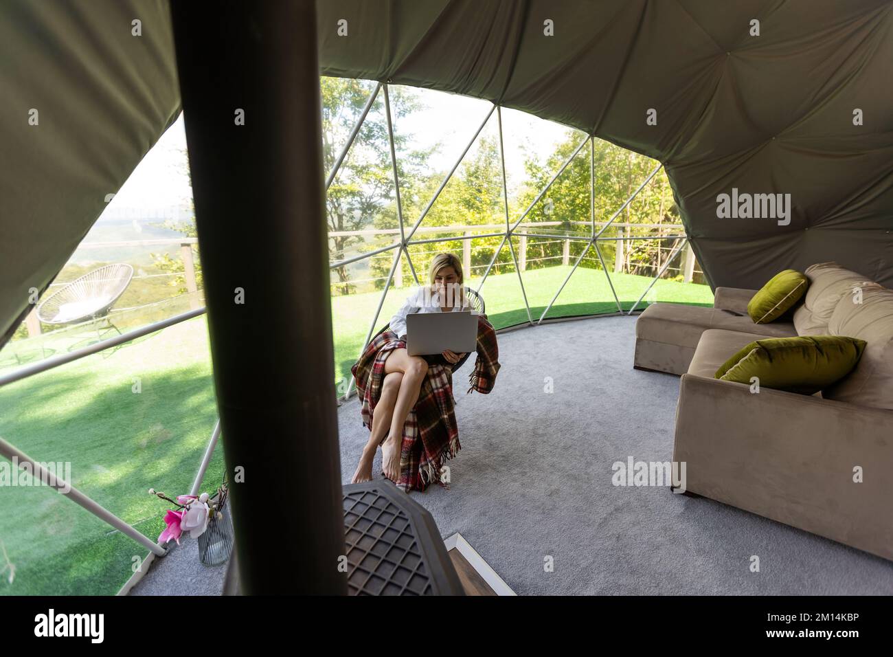 Woman working on laptop geo dome tents. Green, blue background. Cozy, camping, glamping, holiday ...