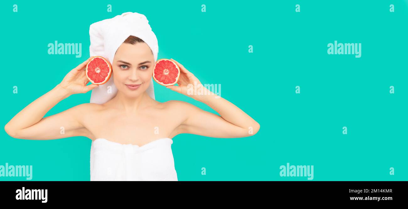 young woman in towel after shower with grapefruit on blue background ...