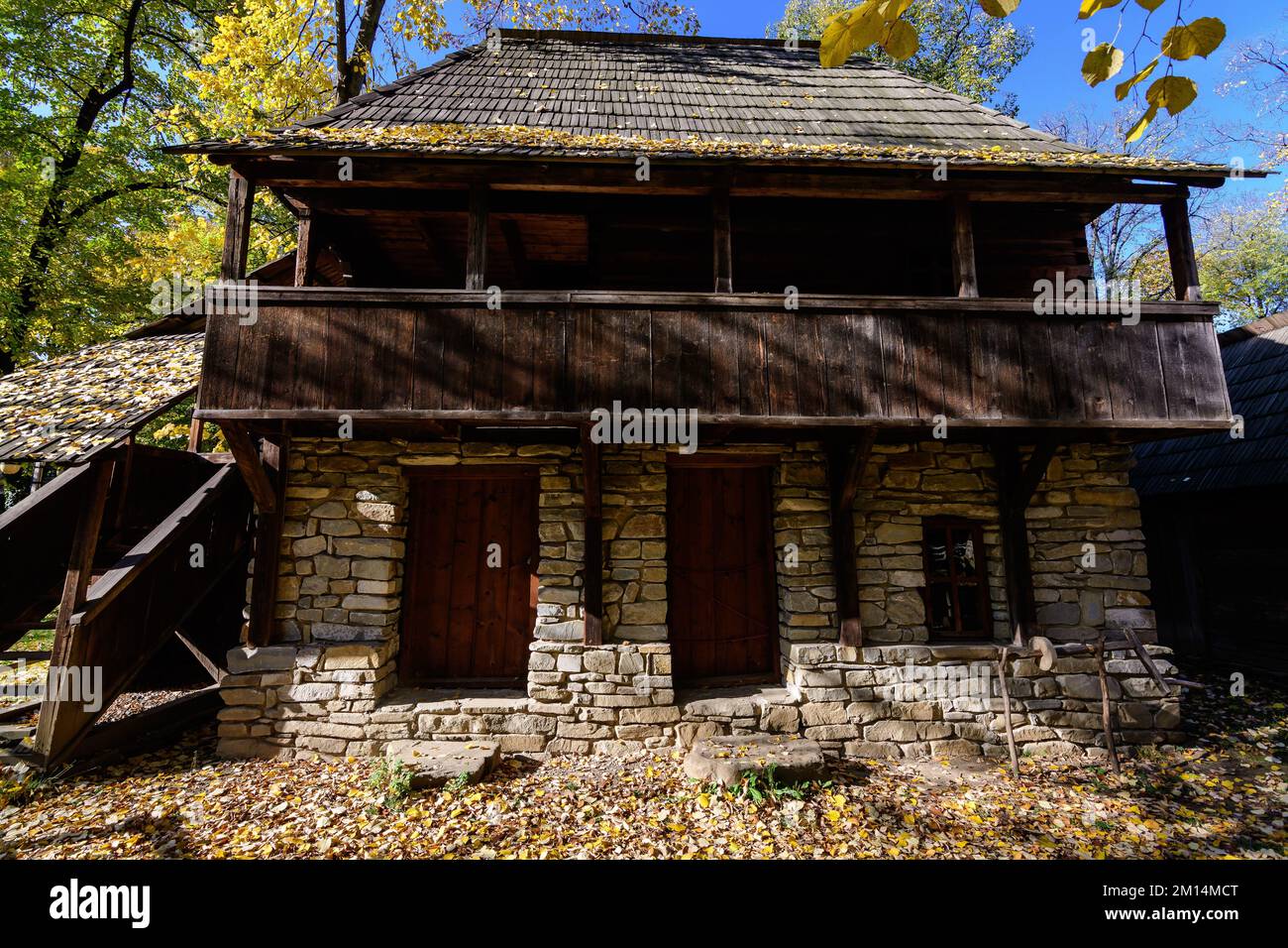 Traditional Romanian house surounded with many old trees with green ...