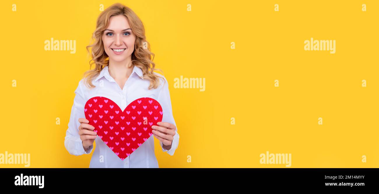 cheerful woman with red love heart on yellow background. Woman isolated ...